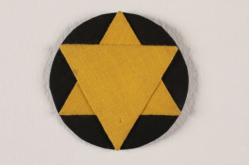 Star of David badge with a yellow star on a black circle worn by a ...